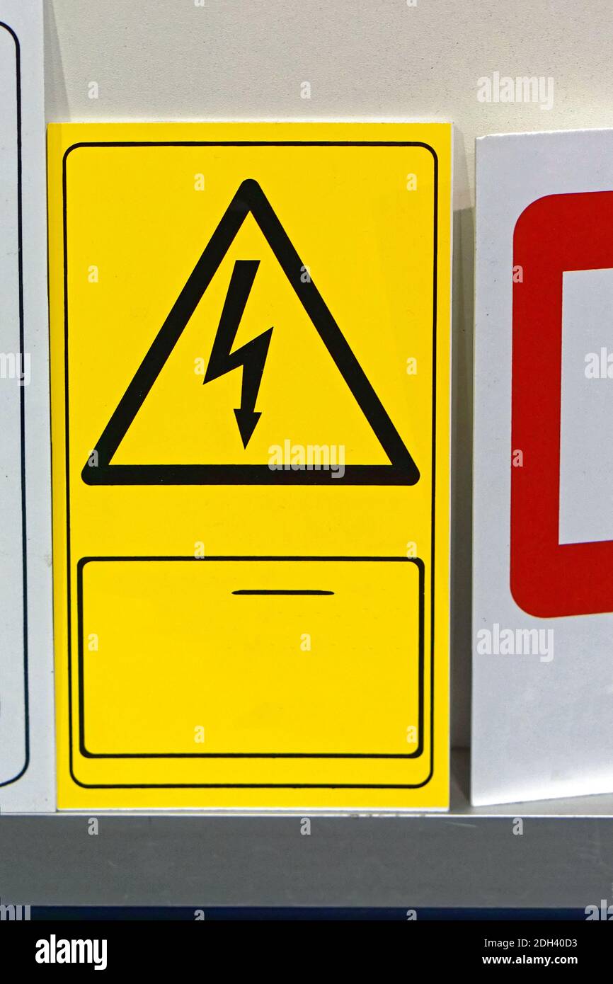 Electric hazard warning sign caution yellow plate Stock Photo - Alamy