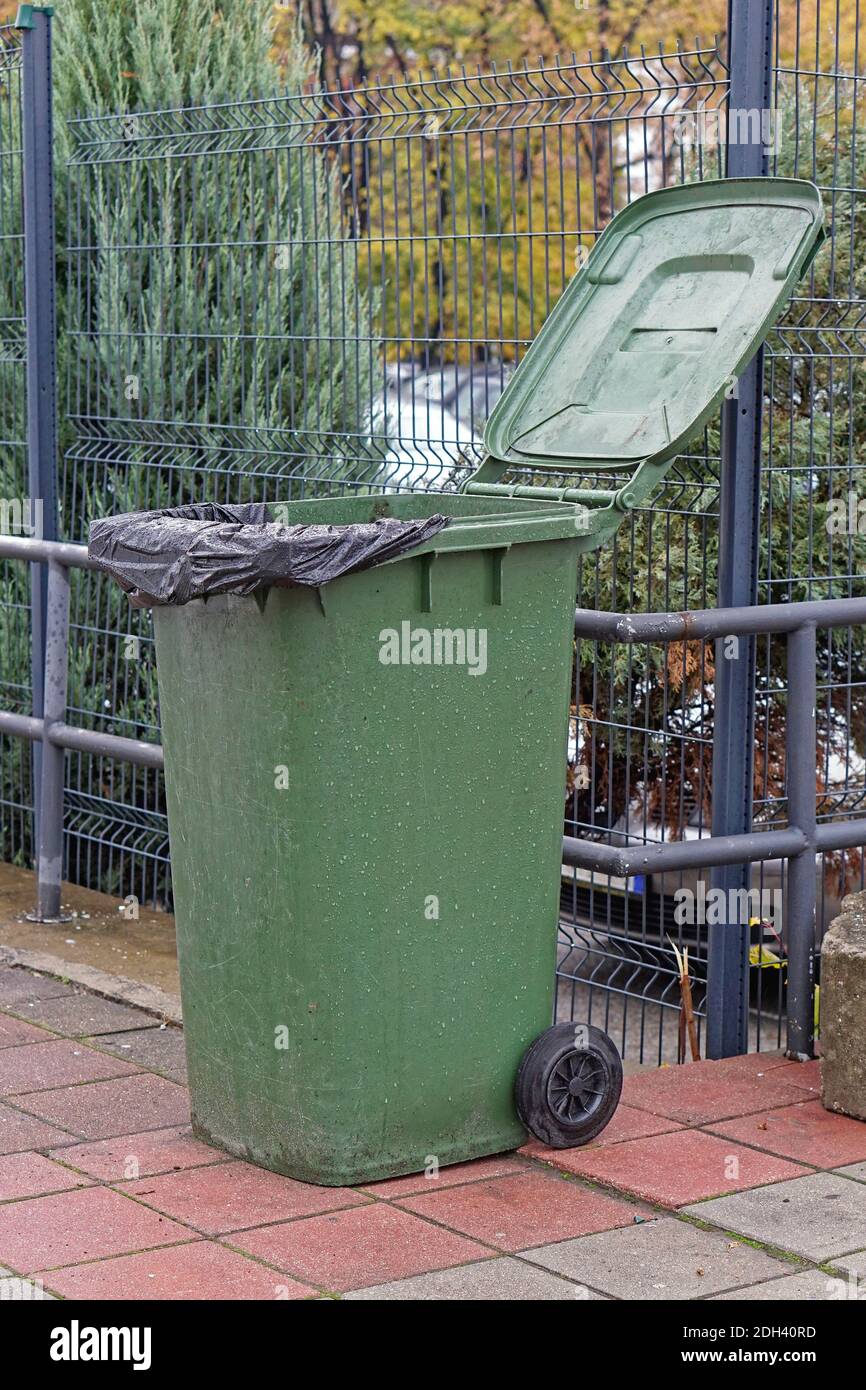 Open lid green plastic wheelie bin outside Stock Photo - Alamy