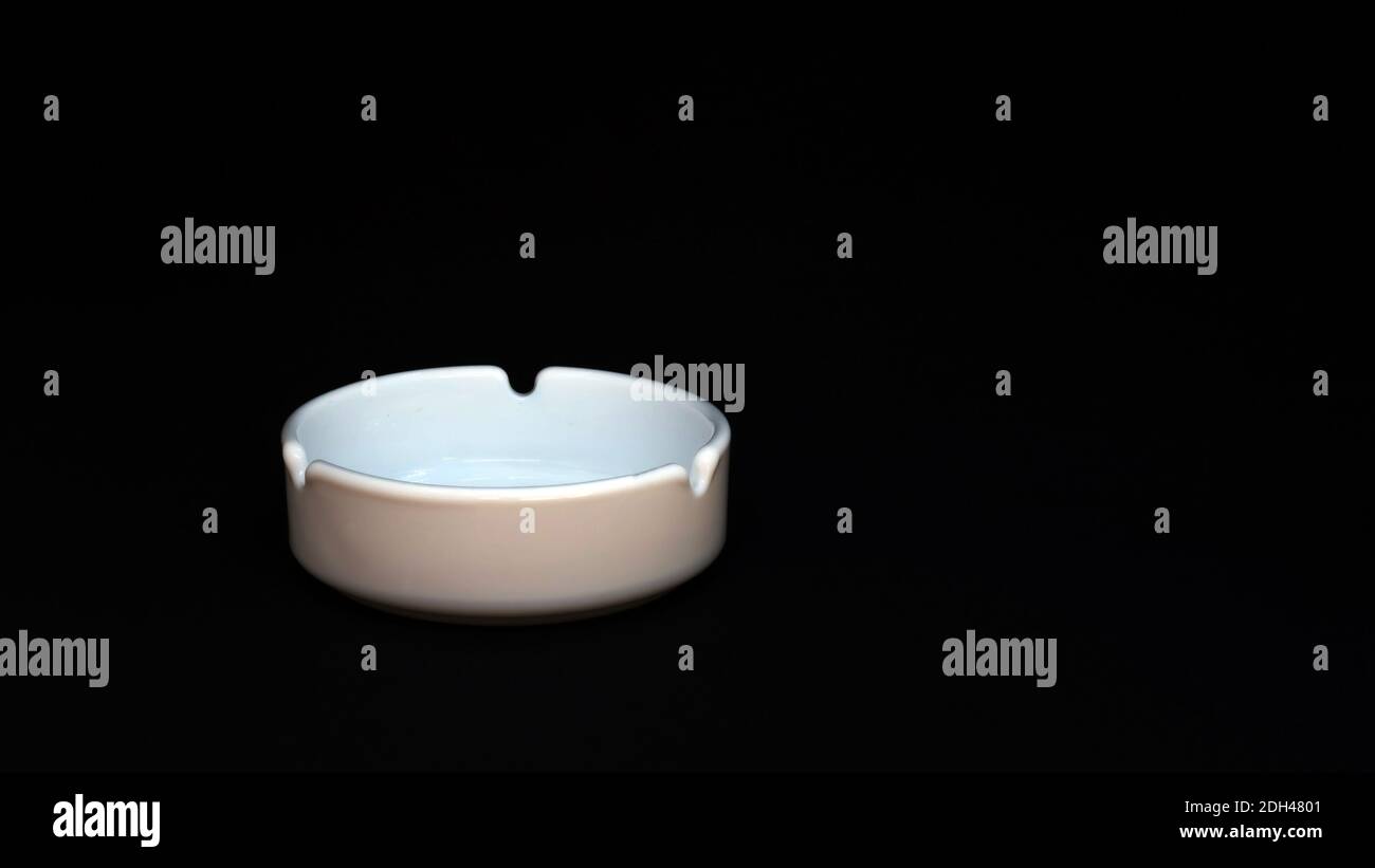 Ashtray on a black background,close up,white ashtray Stock Photo - Alamy
