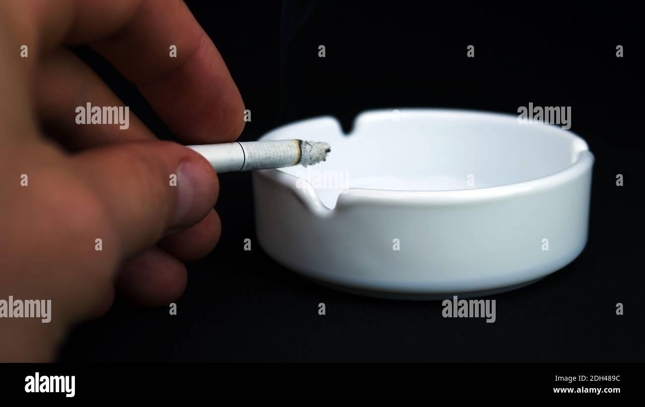 Male hand with a cigarette.In a ashtray,shake off cigarette ash. Large ...