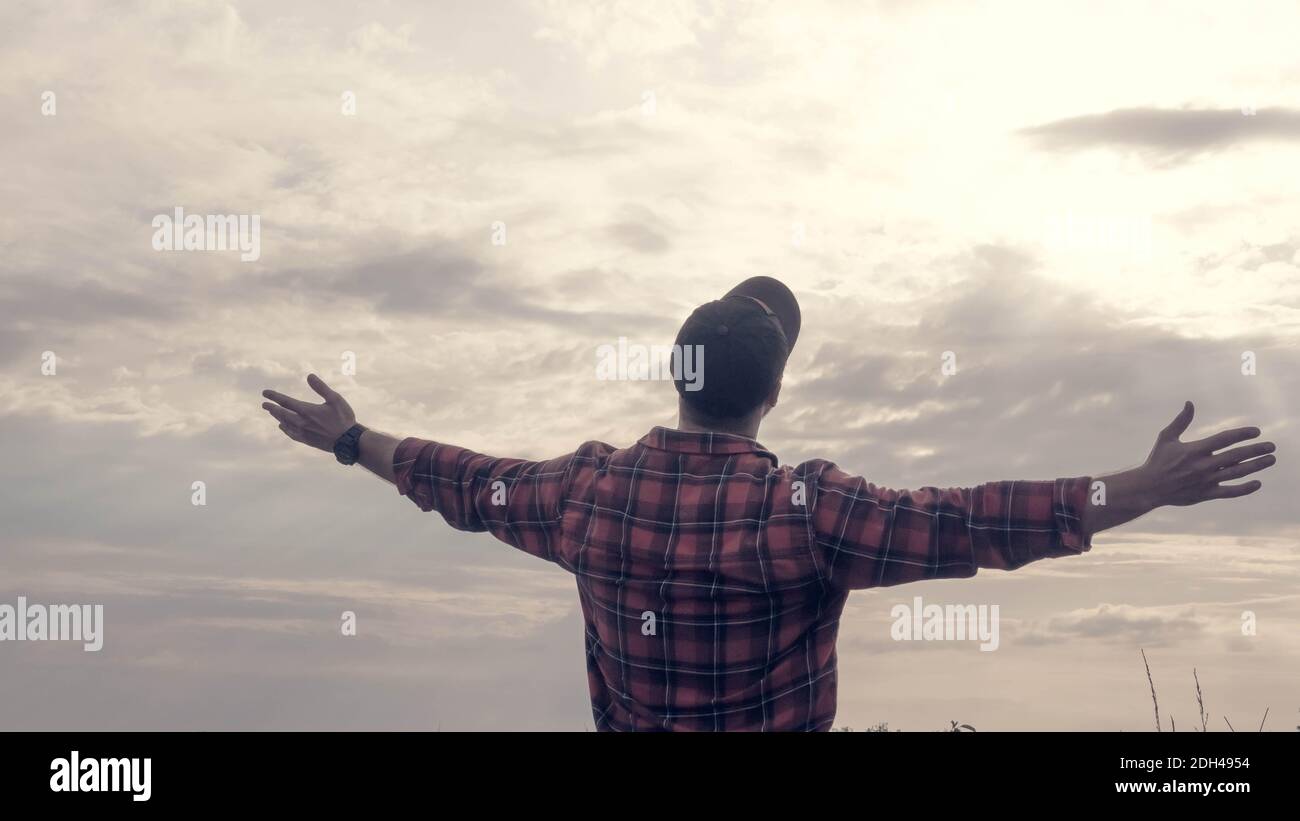 A young man looks into the sky,hands are on the side,the guy pretends ...