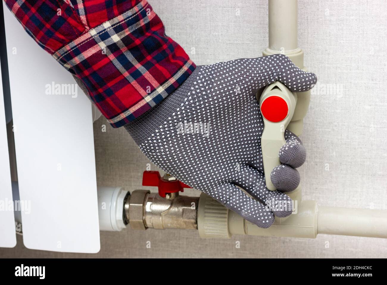 The plumber turns off the tap on the heating system. Heating radiator ...