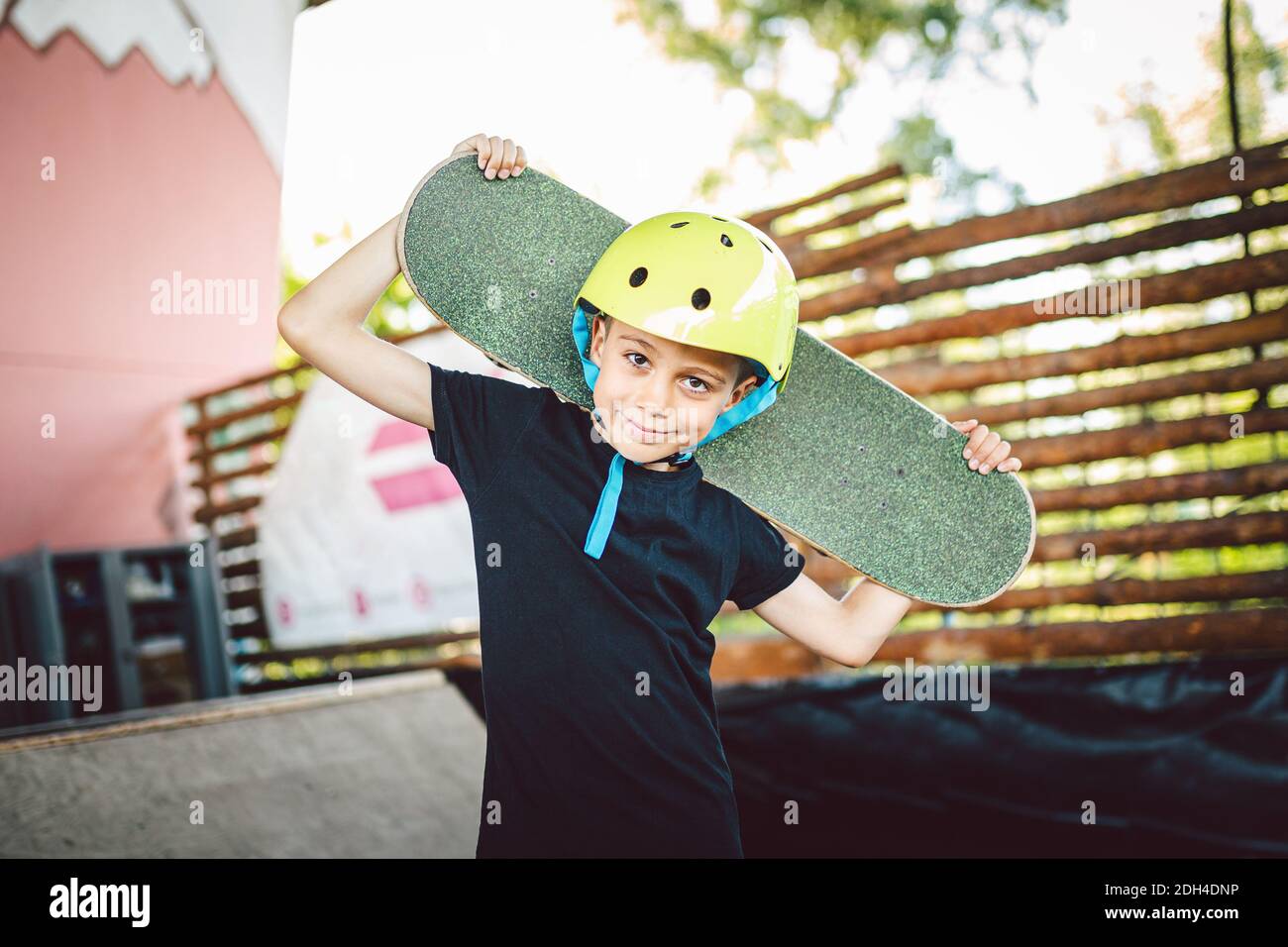 Portrait boy holding skateboard over shoulder. Beautiful kid model ...