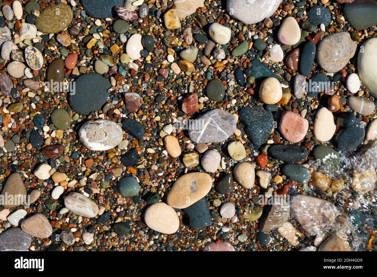 Stone natural background. Wet pebble stones in water Stock Photo - Alamy