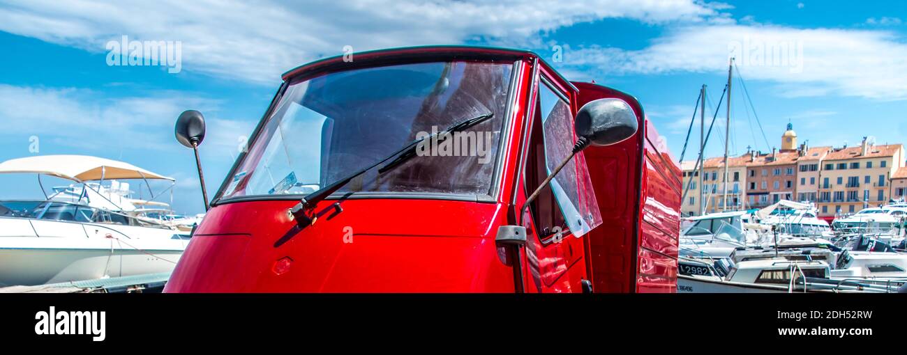 Small red van in Saint-Tropez with its fishing port and yachts Stock ...