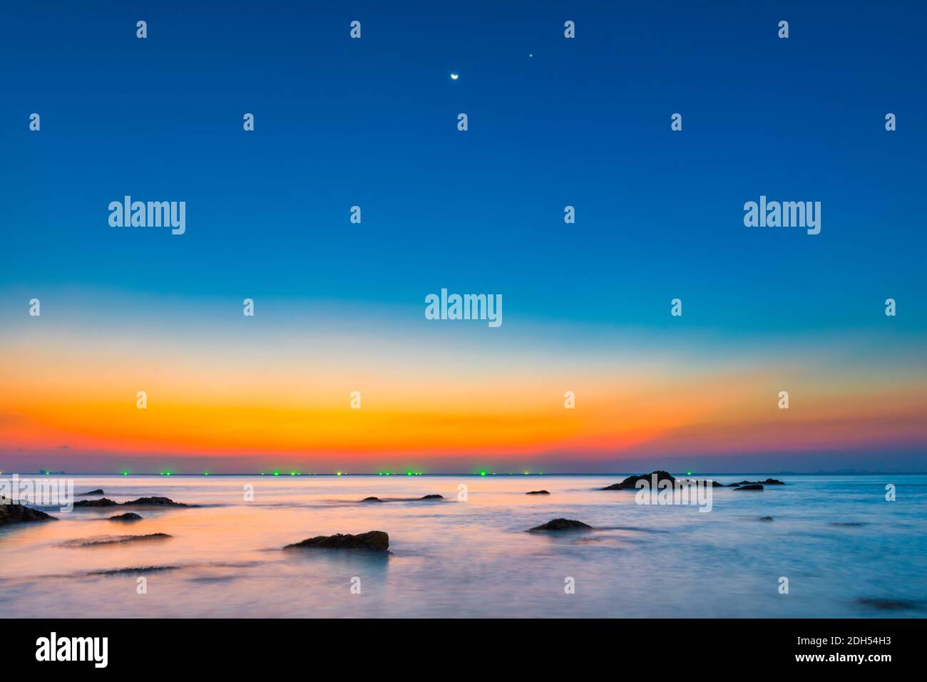 Sunset sea with rocks and sunset night Stock Photo - Alamy