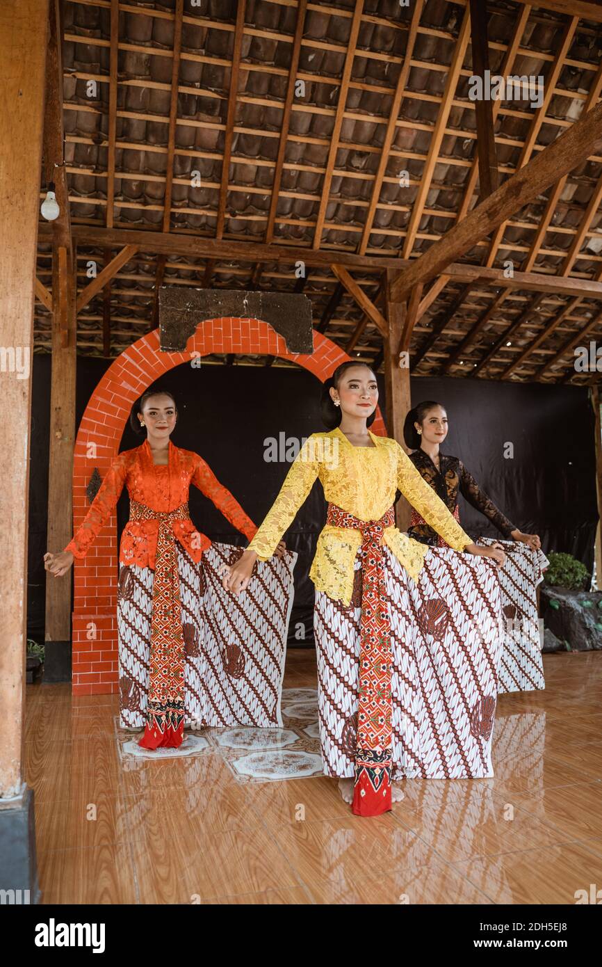 portrait of three young women performing traditional Javanese dancing ...