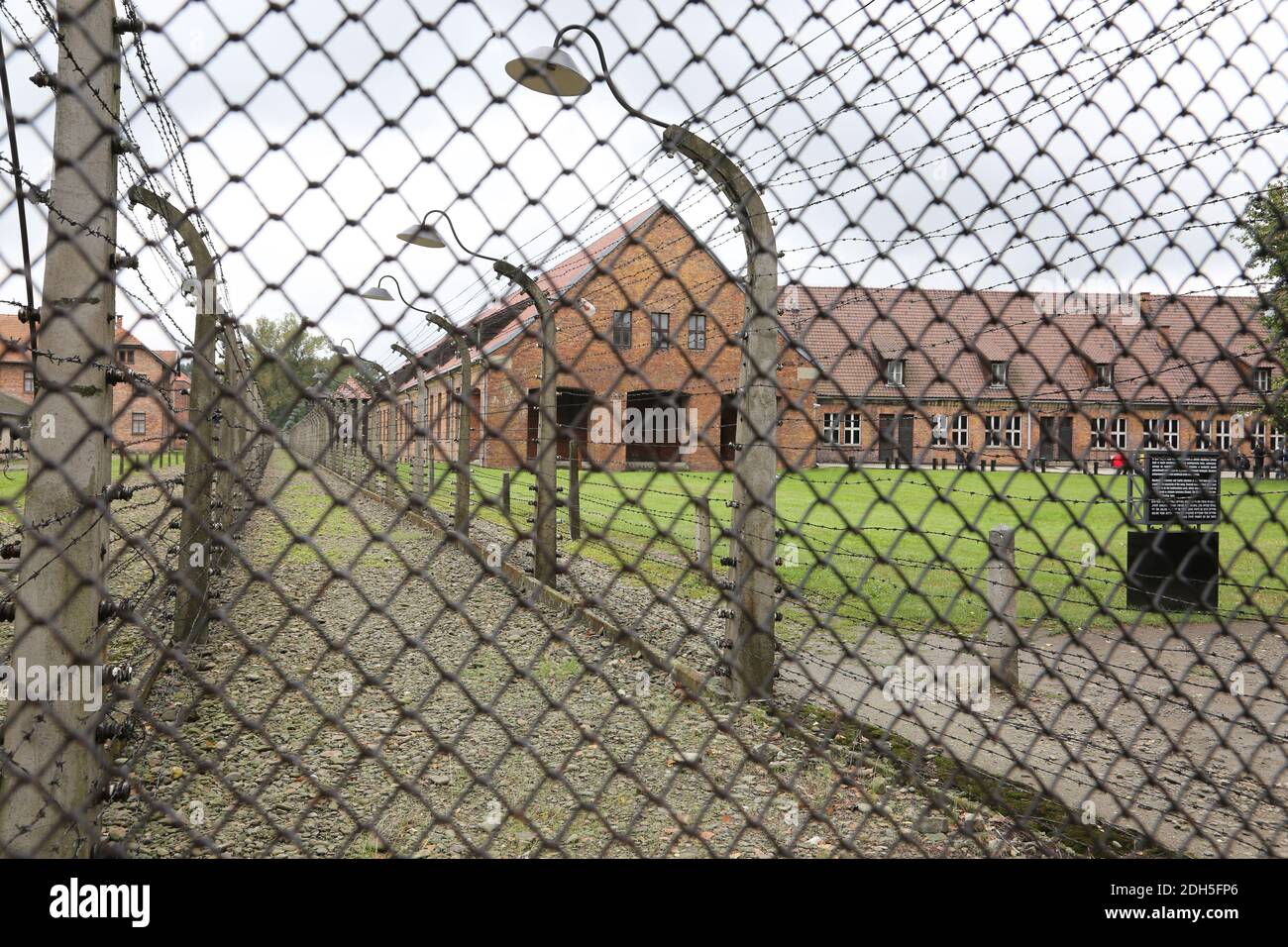 Barracks surrounded by barbed wire fences at the Auschwitz-Birkenau ...