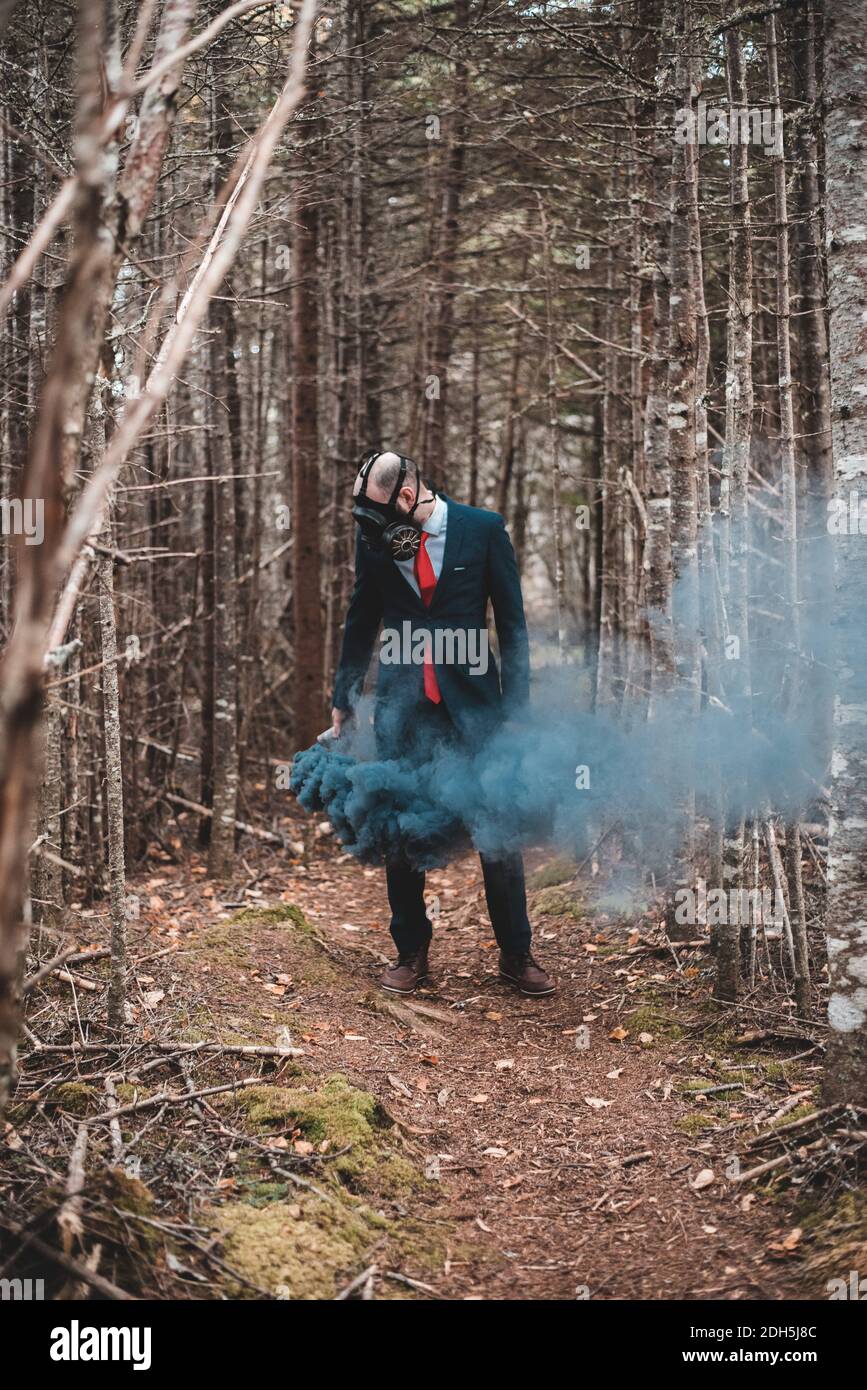 man wearing a business suit and gas mask with a smoke grenade in the ...