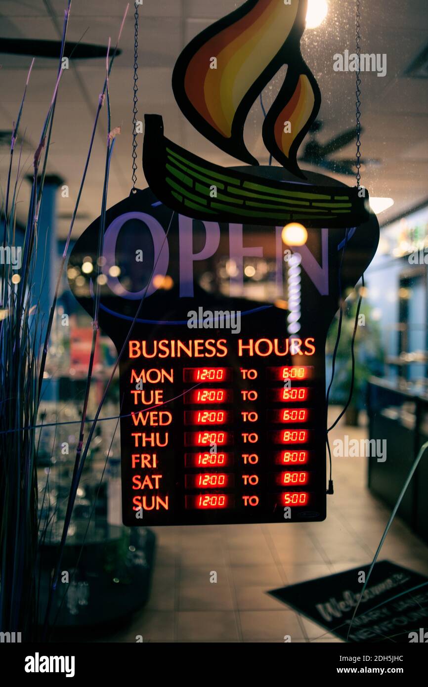 red and green open neon sign with business hhours Stock Photo - Alamy