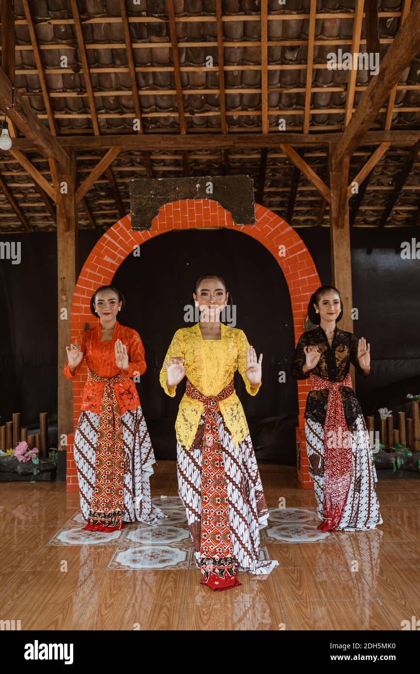 portrait of three young women performing traditional Javanese dancing ...