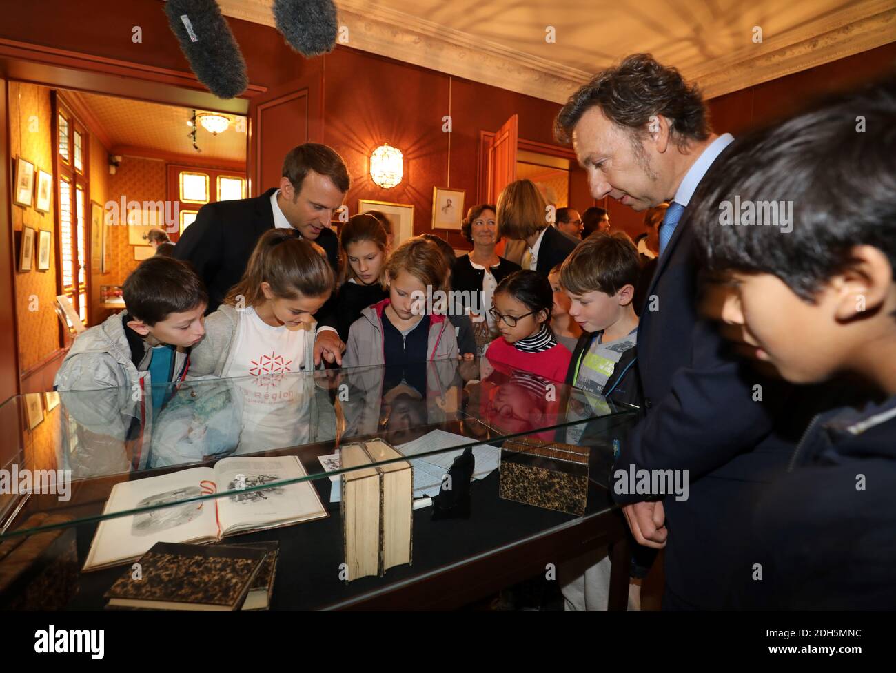 French President Emmanuel Macron (L) gestures to a display as he stands ...