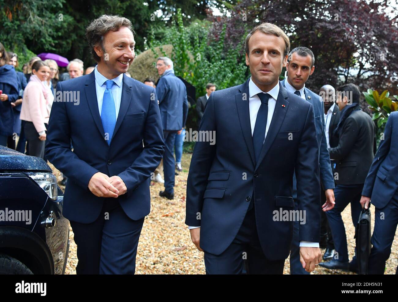 French President Emmanuel Macron (R) shakes hands with television host ...