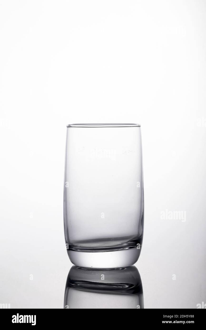 A vertical shot of glass for water on a reflecting surface Stock Photo ...