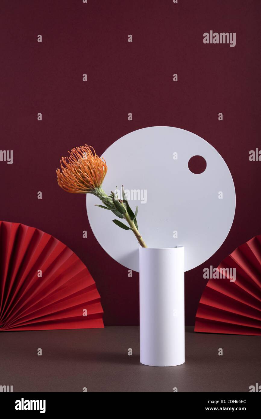 A vertical shot of a decorative vase with a protea flower with Chinese ...