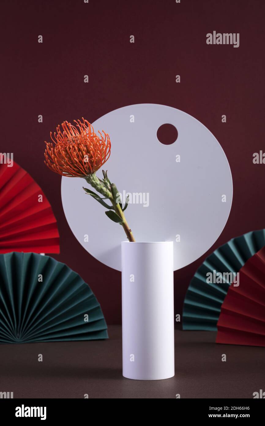 A vertical shot of a decorative vase with a protea flower with Chinese ...