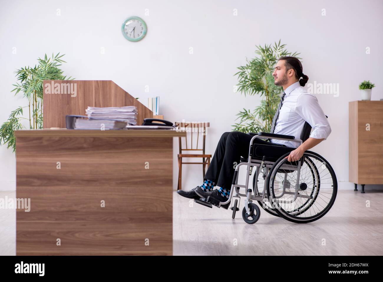 Young disabled employee suffering at workplace Stock Photo - Alamy