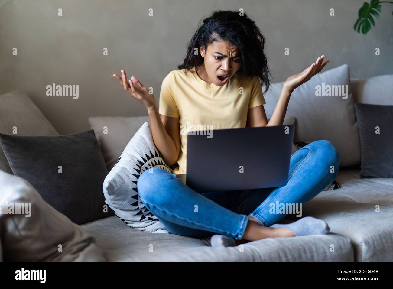 Confused woman sit on couch at home having malfunction problems working ...