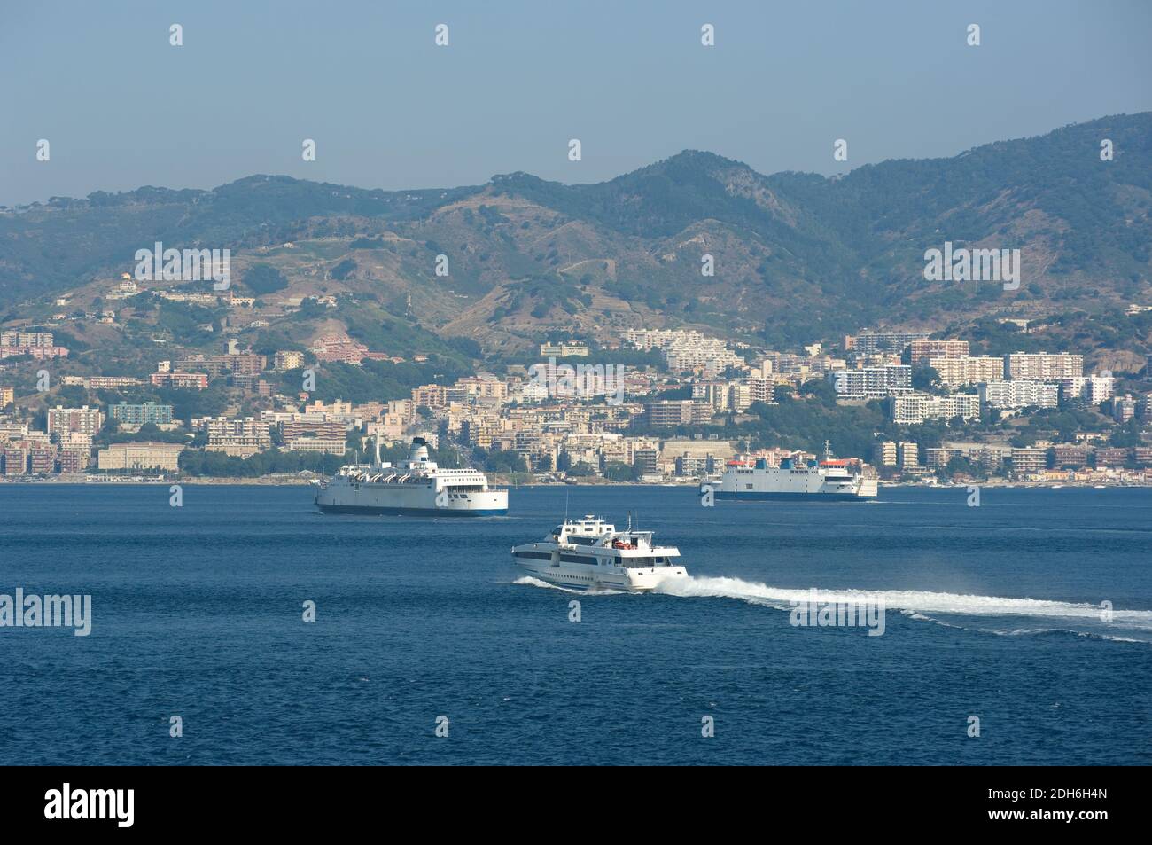 ferryboats in the canal of Messina on the background the city's skyline ...
