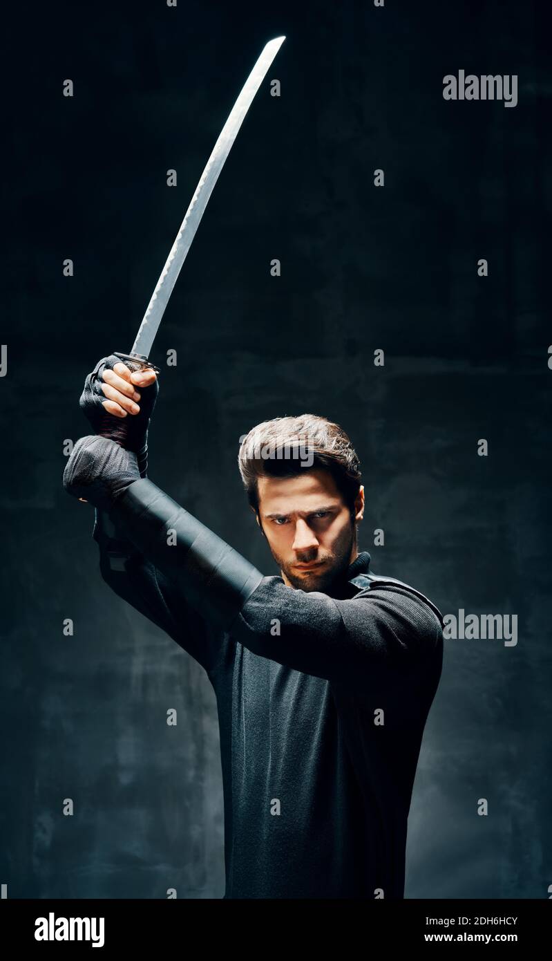 Warrior man posing with a sword ready to stab enemy Stock Photo - Alamy