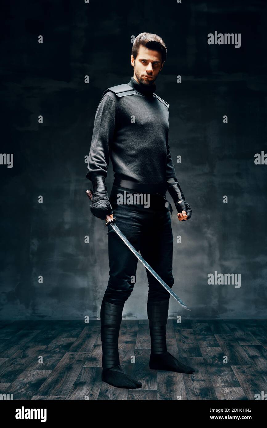 Full length portrait of warrior man posing with a sword Stock Photo - Alamy