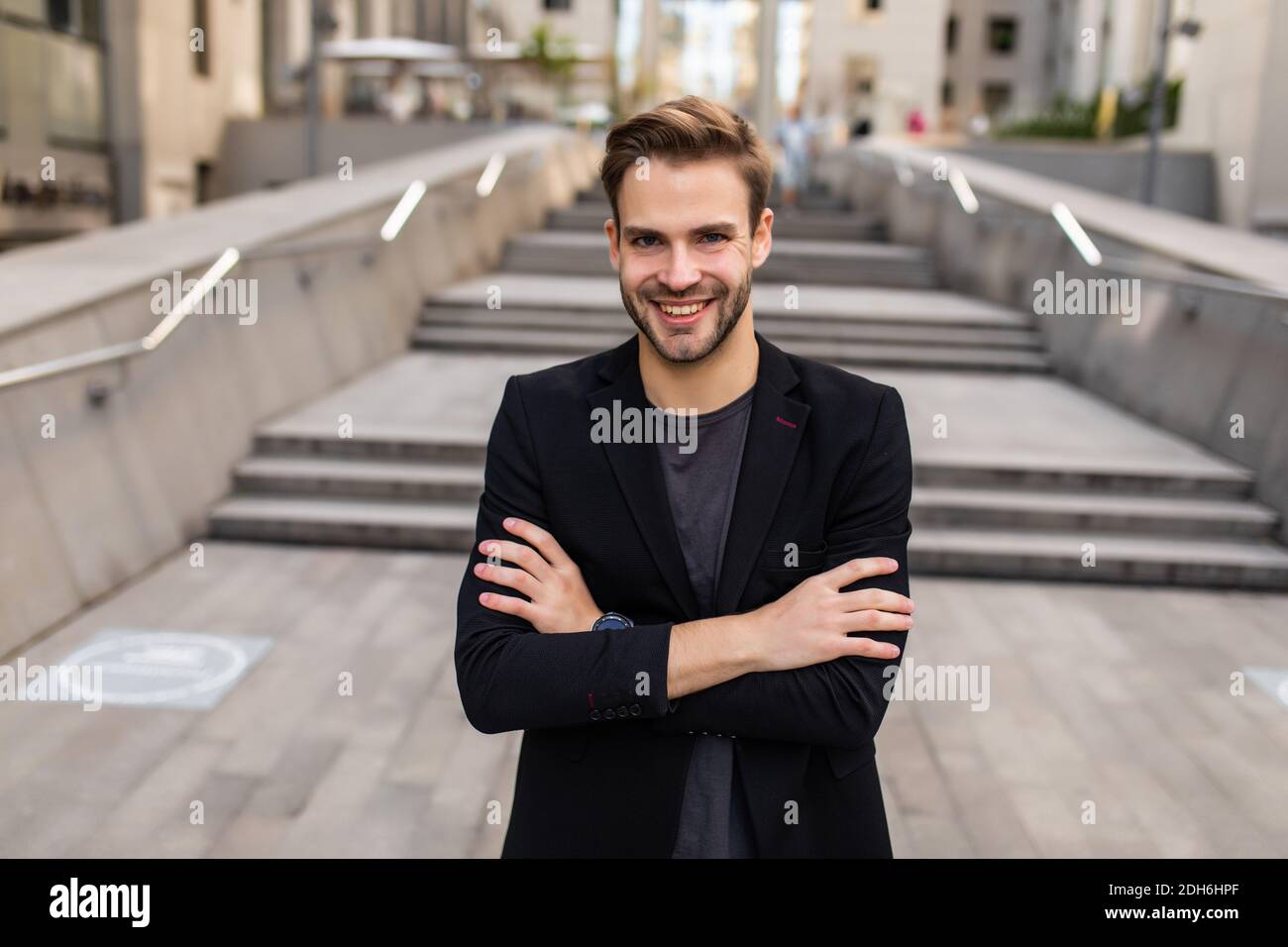 Caucasian male banker with crossed hands standing at urbanity in ...