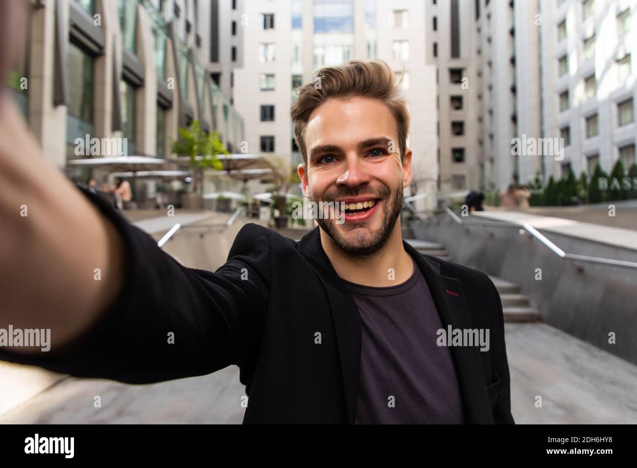 Photo of beautiful businessman dressed in formal suit smiling at camera ...
