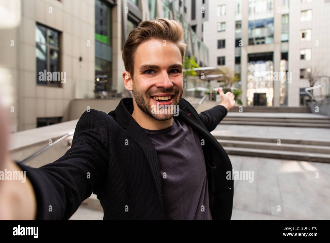 Photo of beautiful businessman dressed in formal suit smiling at camera ...