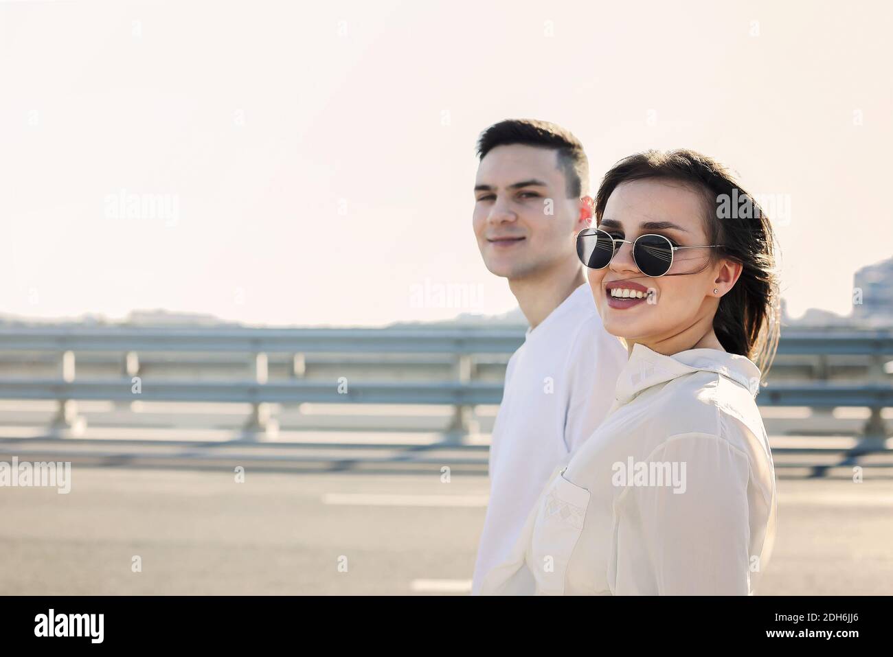 Happy couple walking along bridge Stock Photo - Alamy