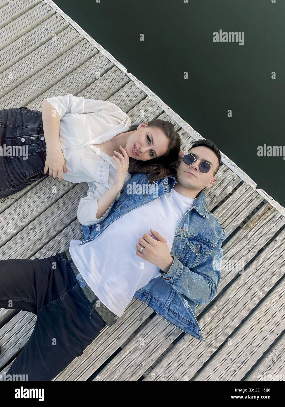 Young couple relaxing on pier in summer Stock Photo - Alamy