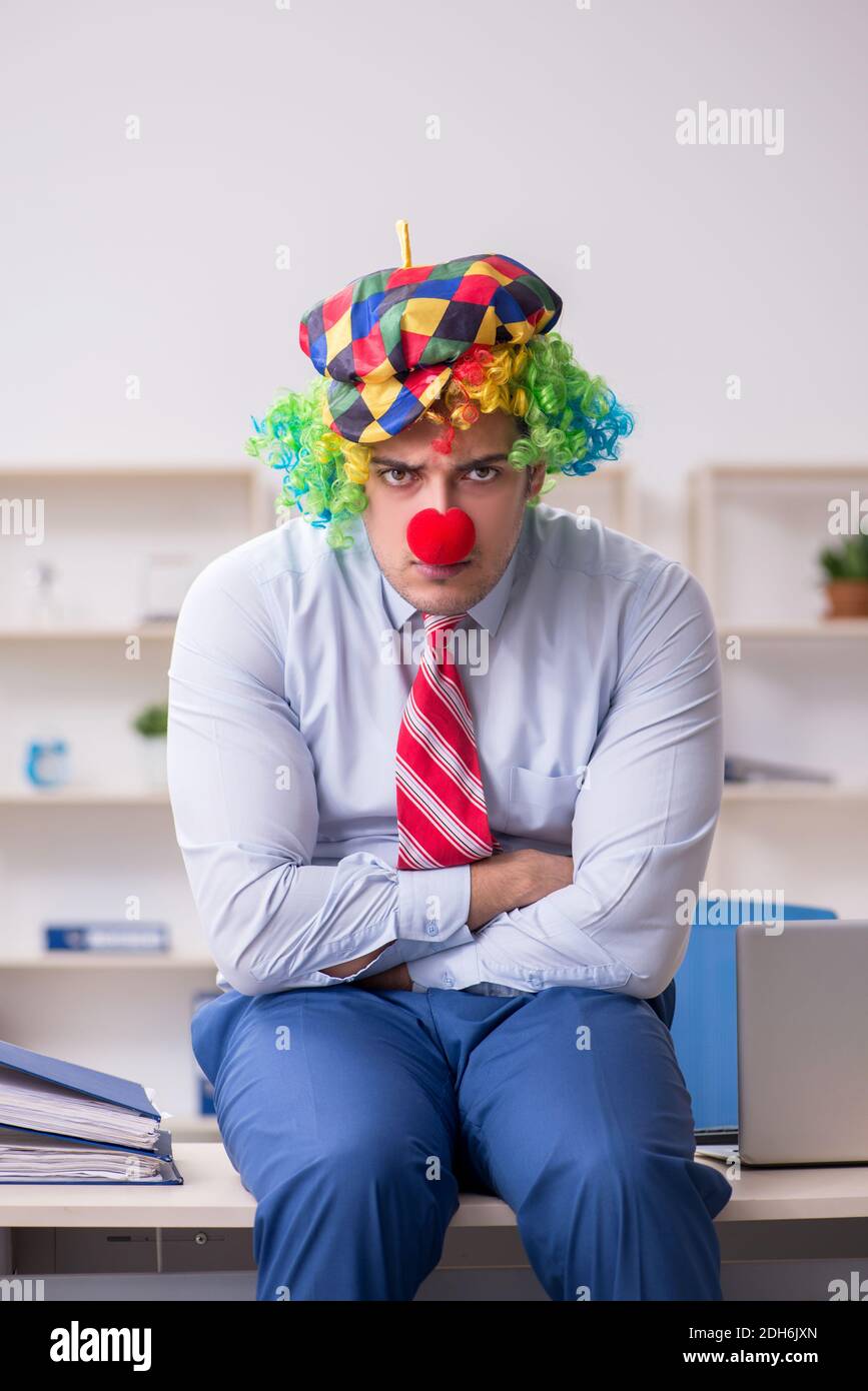 Funny employee clown working in the office Stock Photo - Alamy