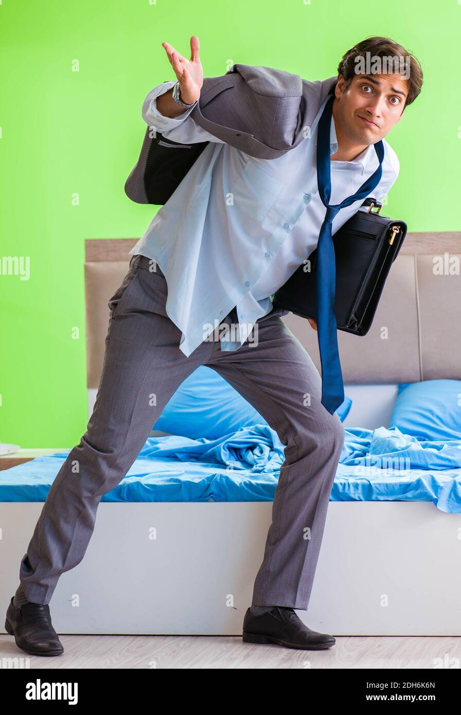 Employee in the bedroom being late for his job Stock Photo - Alamy