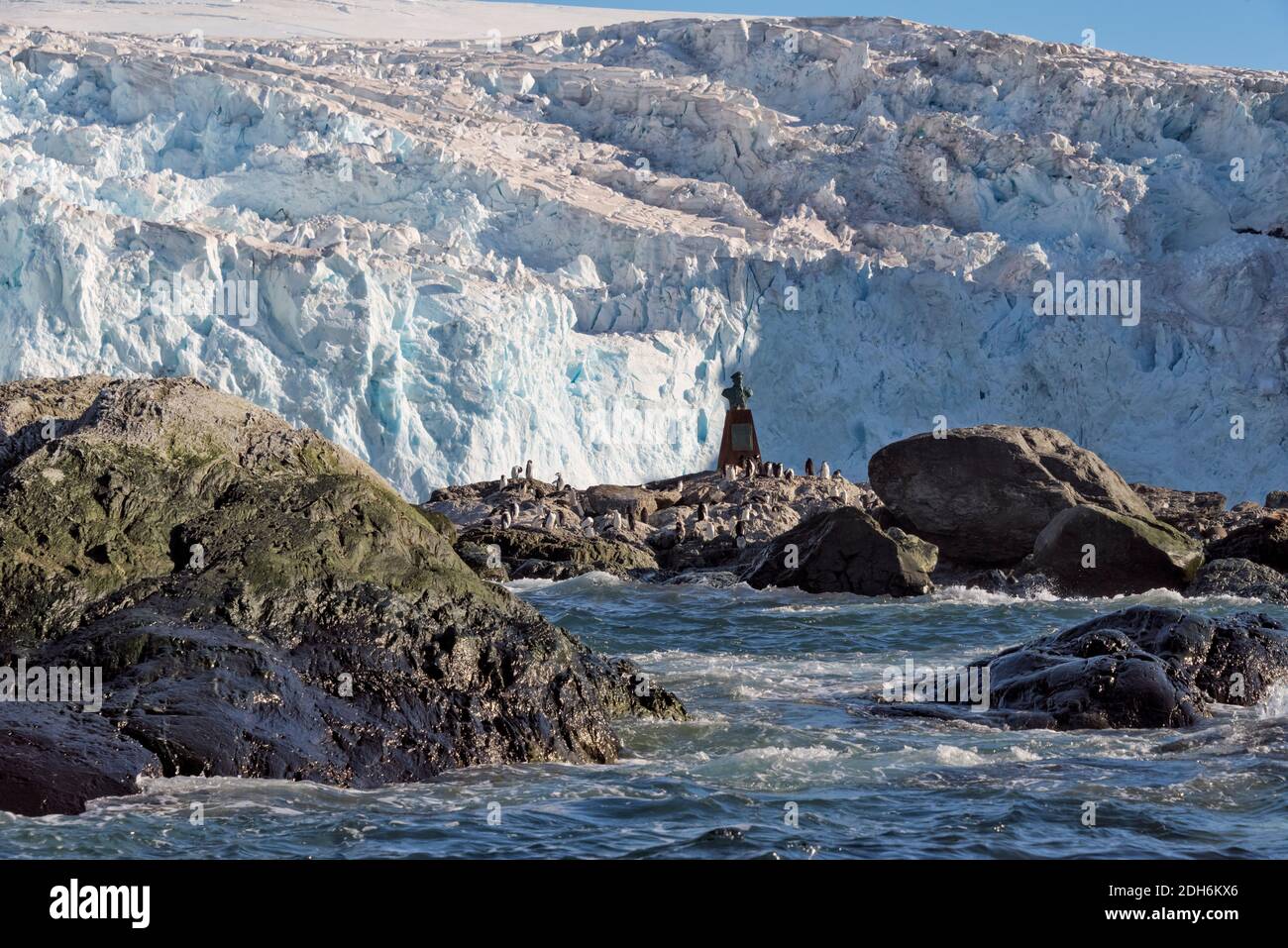 Penguins and bust of Captain Luis Pardo Villalon on the beach, Point ...