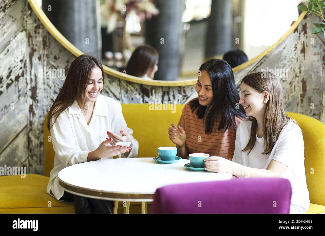 Happy multiethnic friends meeting in cafeteria Stock Photo - Alamy