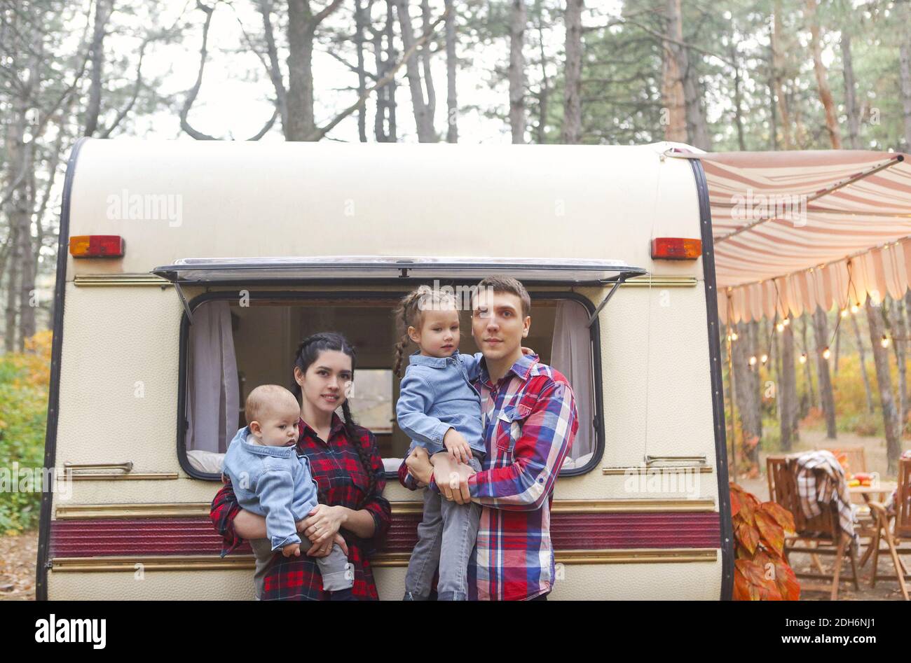 Portrait of the smiling happy family with kids in the house on wheels ...