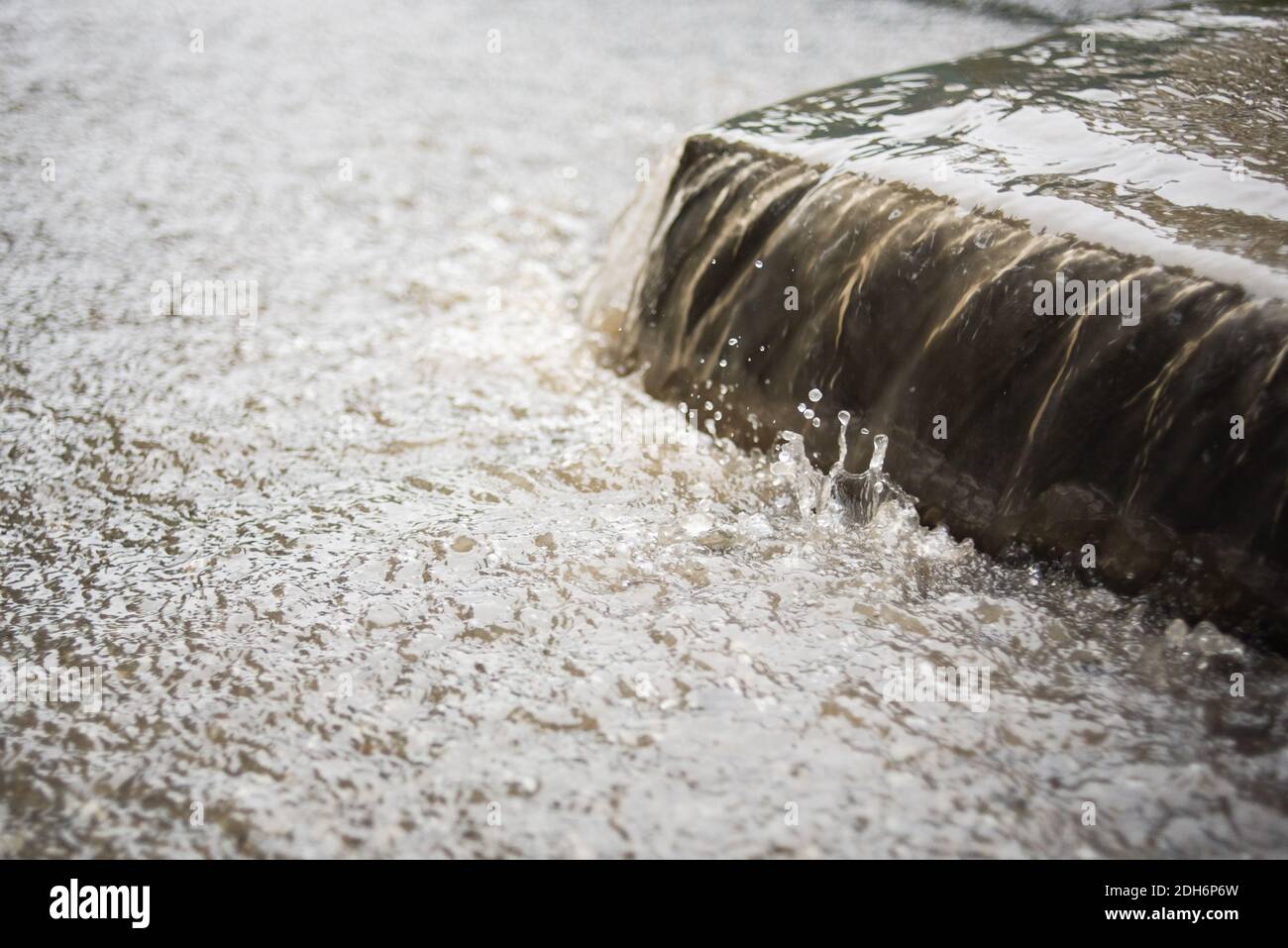The stream of water flows down from the sidewalk. Heavy rain. Street ...