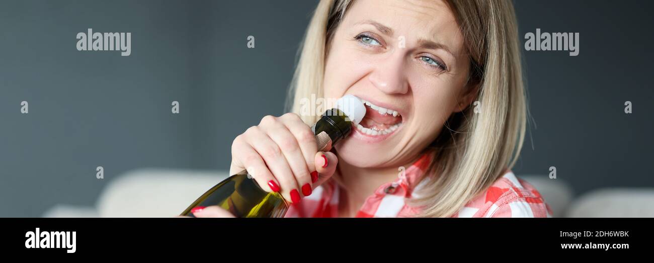 Woman opens bottle of champagne with her teeth Stock Photo - Alamy