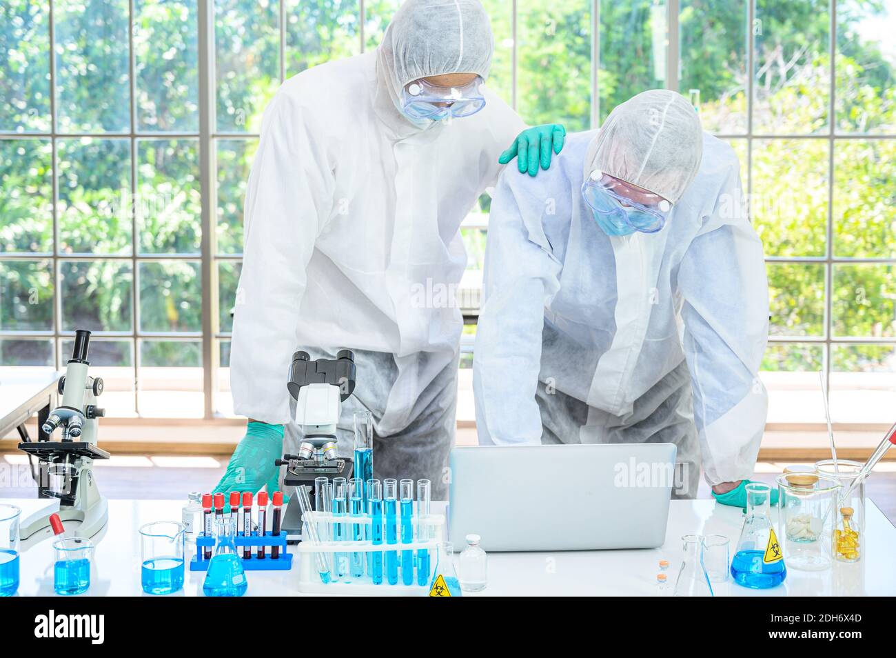 Couple male scientist wearing protection suit working with Microscope ...