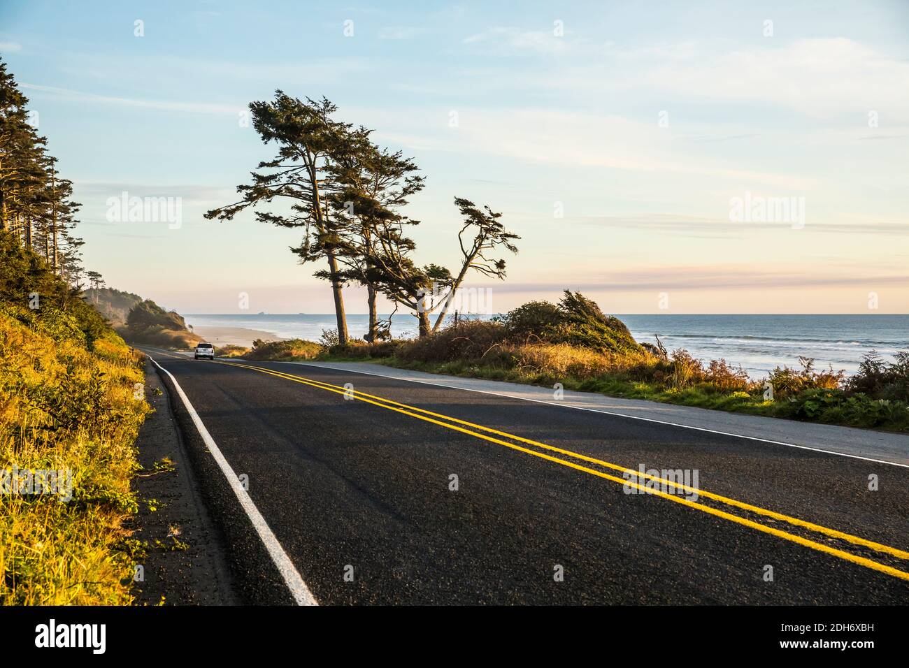 A car driving south on highway 101 along the Olympic Peninsula coast as ...