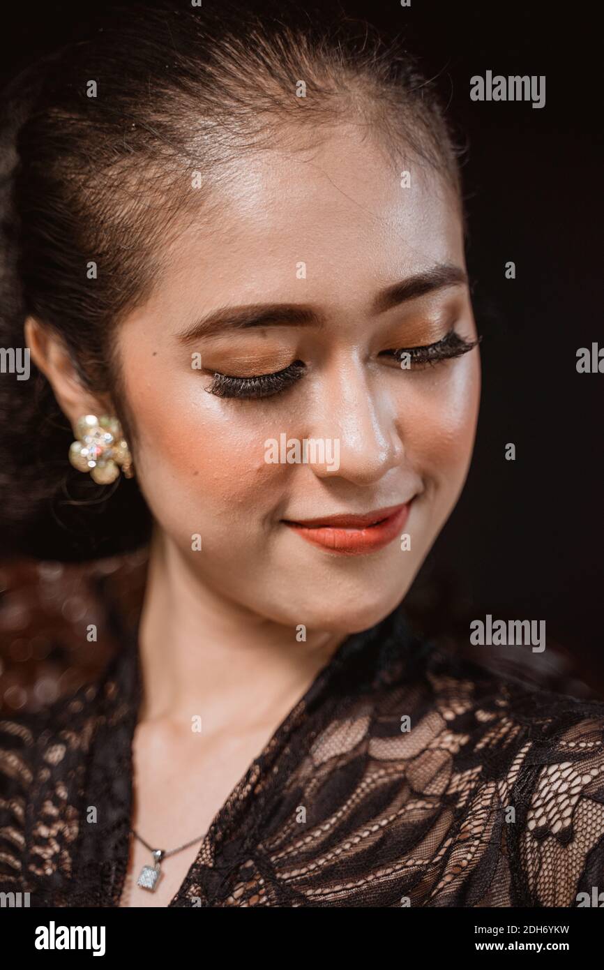 portrait of a young woman wearing Javanese kebaya traditional clothes ...