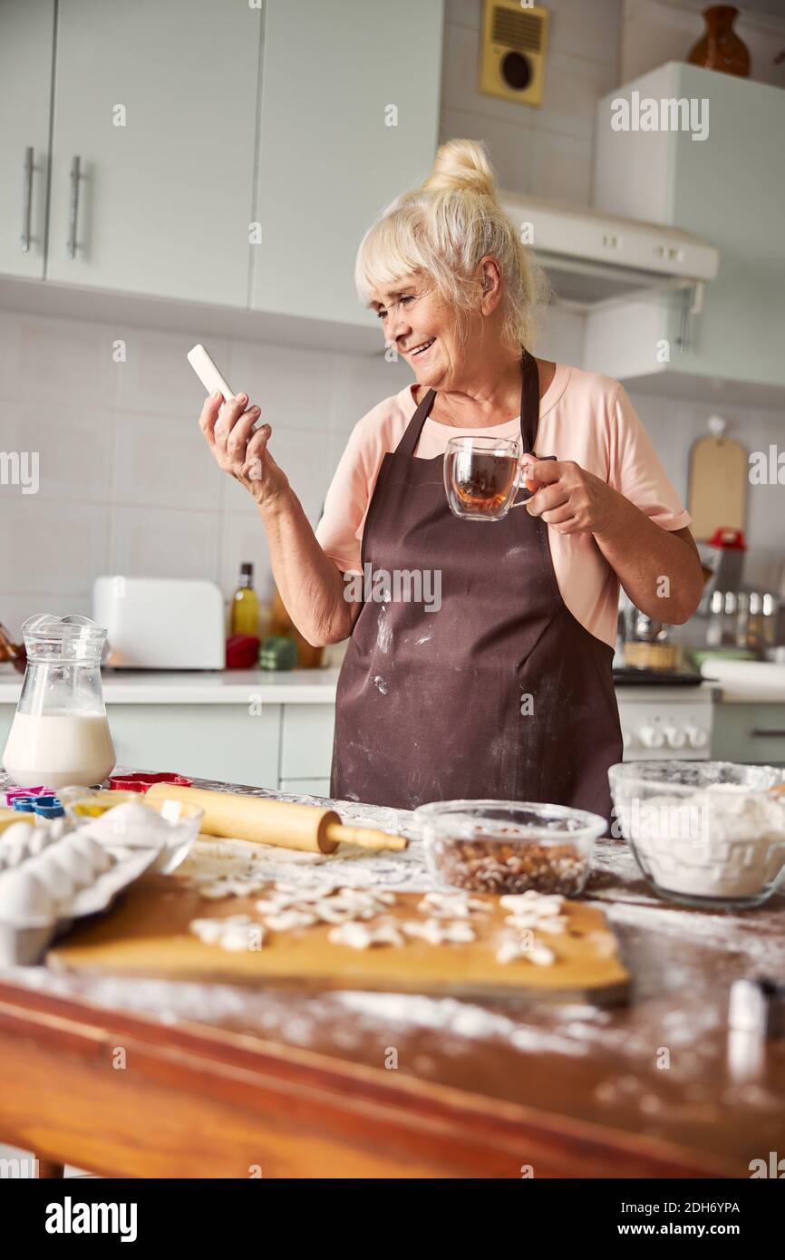 Taking a break from cooking for video-call with family Stock Photo - Alamy