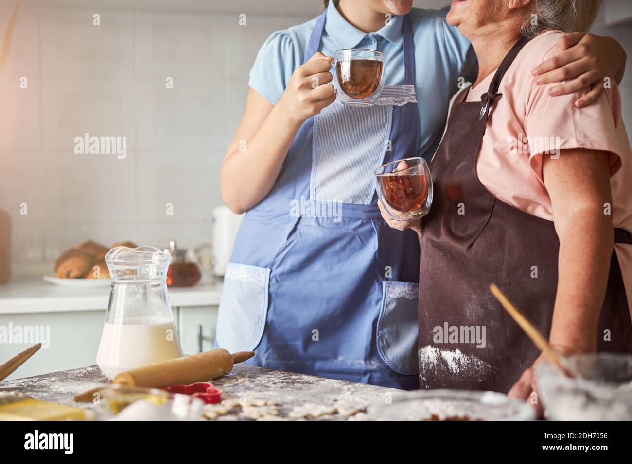 Two bakers having tea and hugging near kitchen table Stock Photo - Alamy