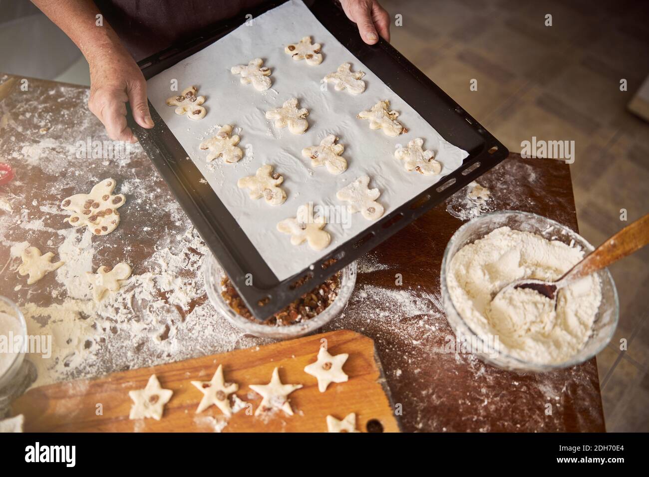 Skillful baker having a load of cookies ready for baking Stock Photo ...