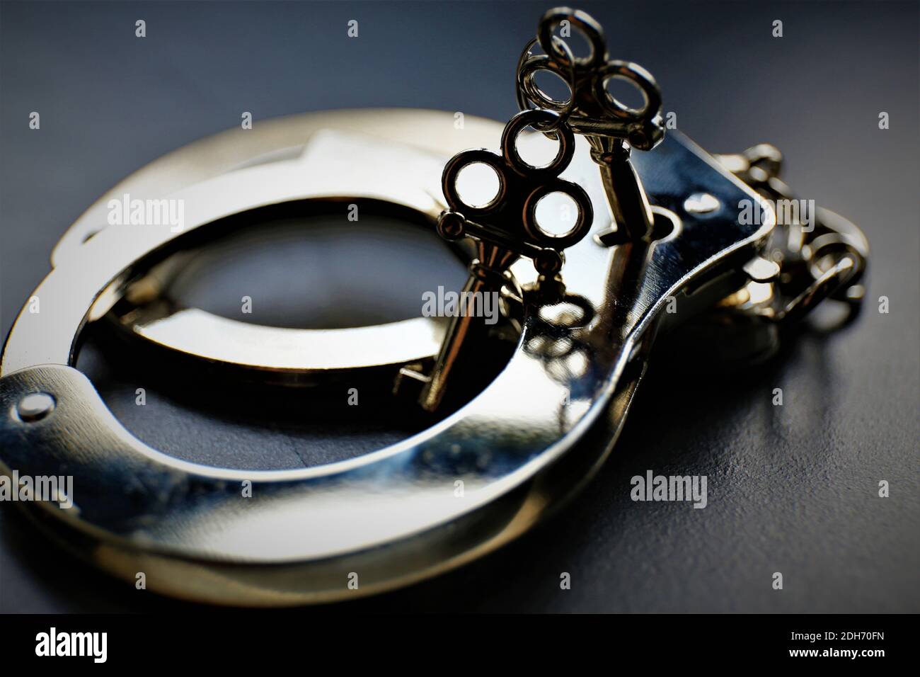 handcuffs on the table Stock Photo - Alamy