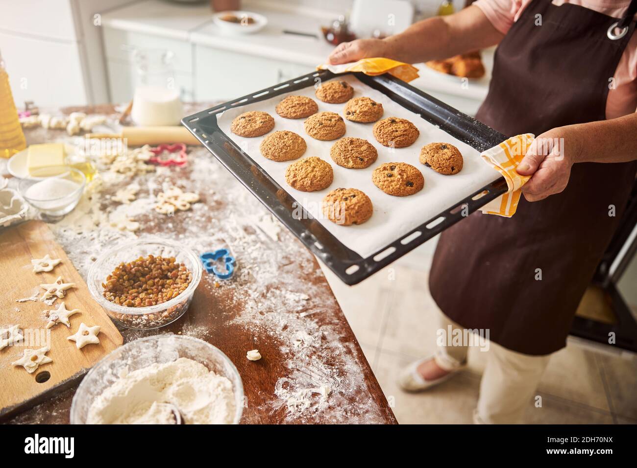 Cautious lady carrying a tray with hot cookies to table Stock Photo - Alamy
