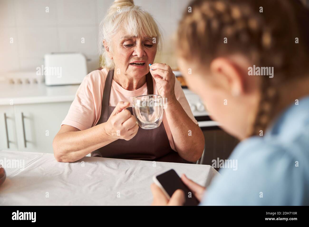 Sick senior lady taking medication at home Stock Photo - Alamy