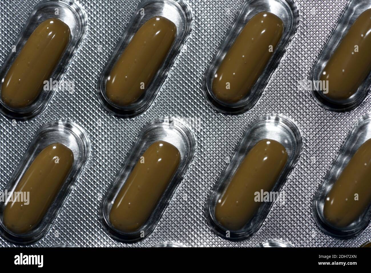 A closeup of a medicinal capsule on a silver pad Stock Photo - Alamy