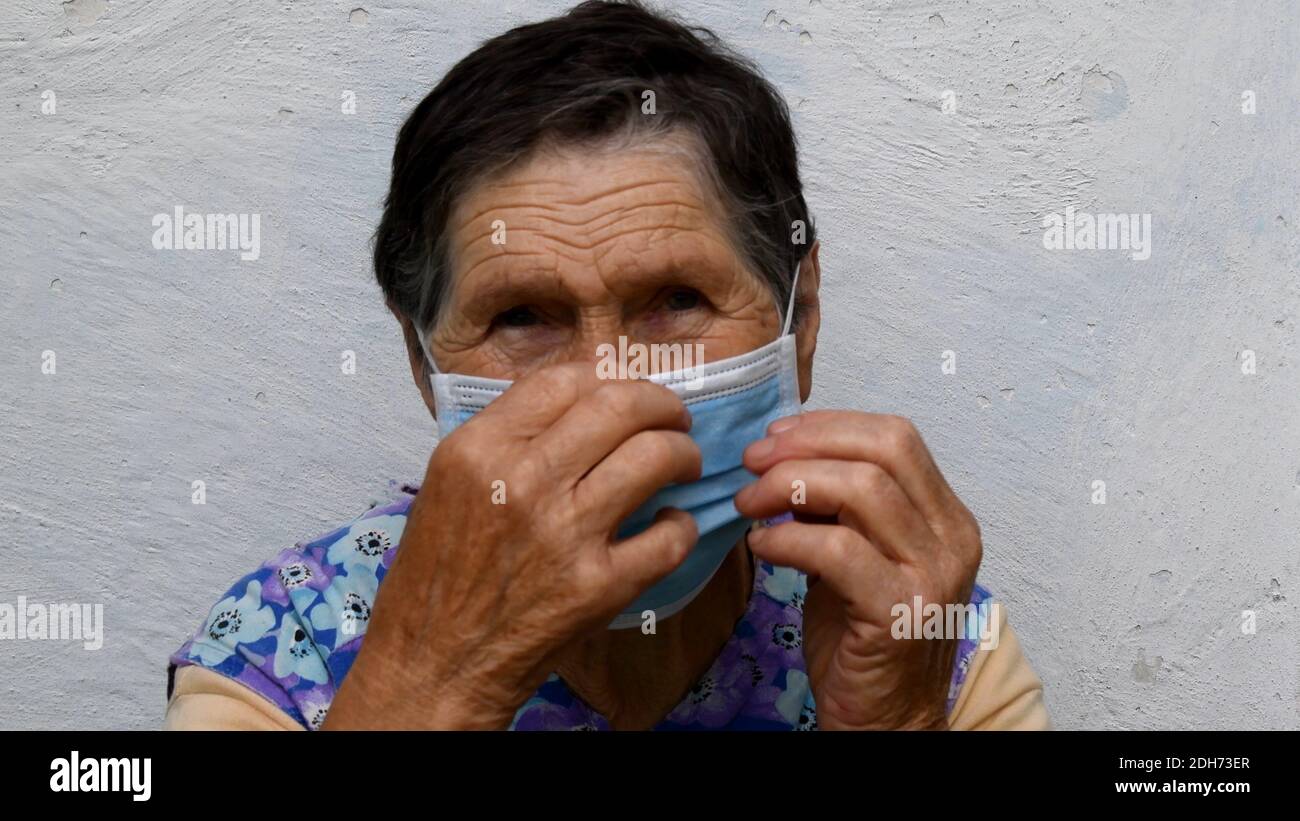 Senior woman of 80 years old put on protective medical face mask and ...