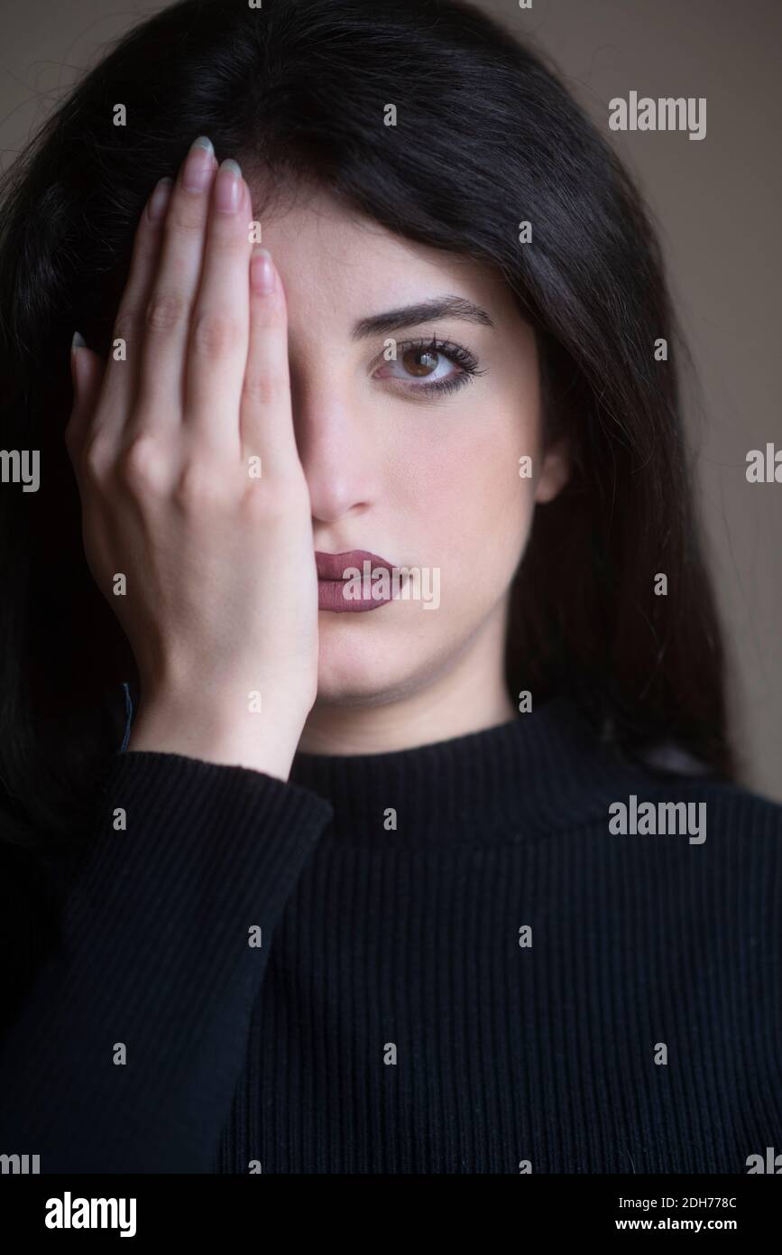 Beautiful young woman hand covering face Stock Photo - Alamy