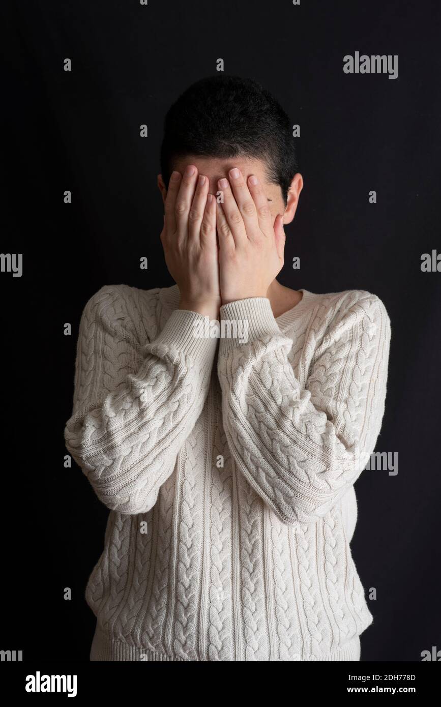 Stressed young woman with short hair hiding face with hands Stock Photo ...